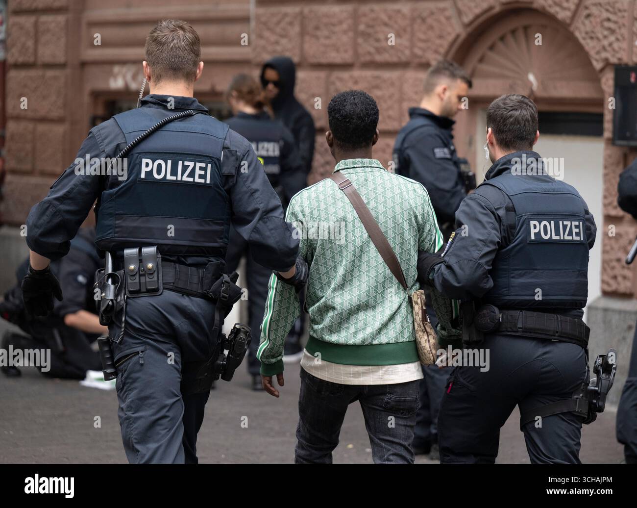 01 September 2025, Hesse, Frankfurt/Main: Police officers lead a man ...