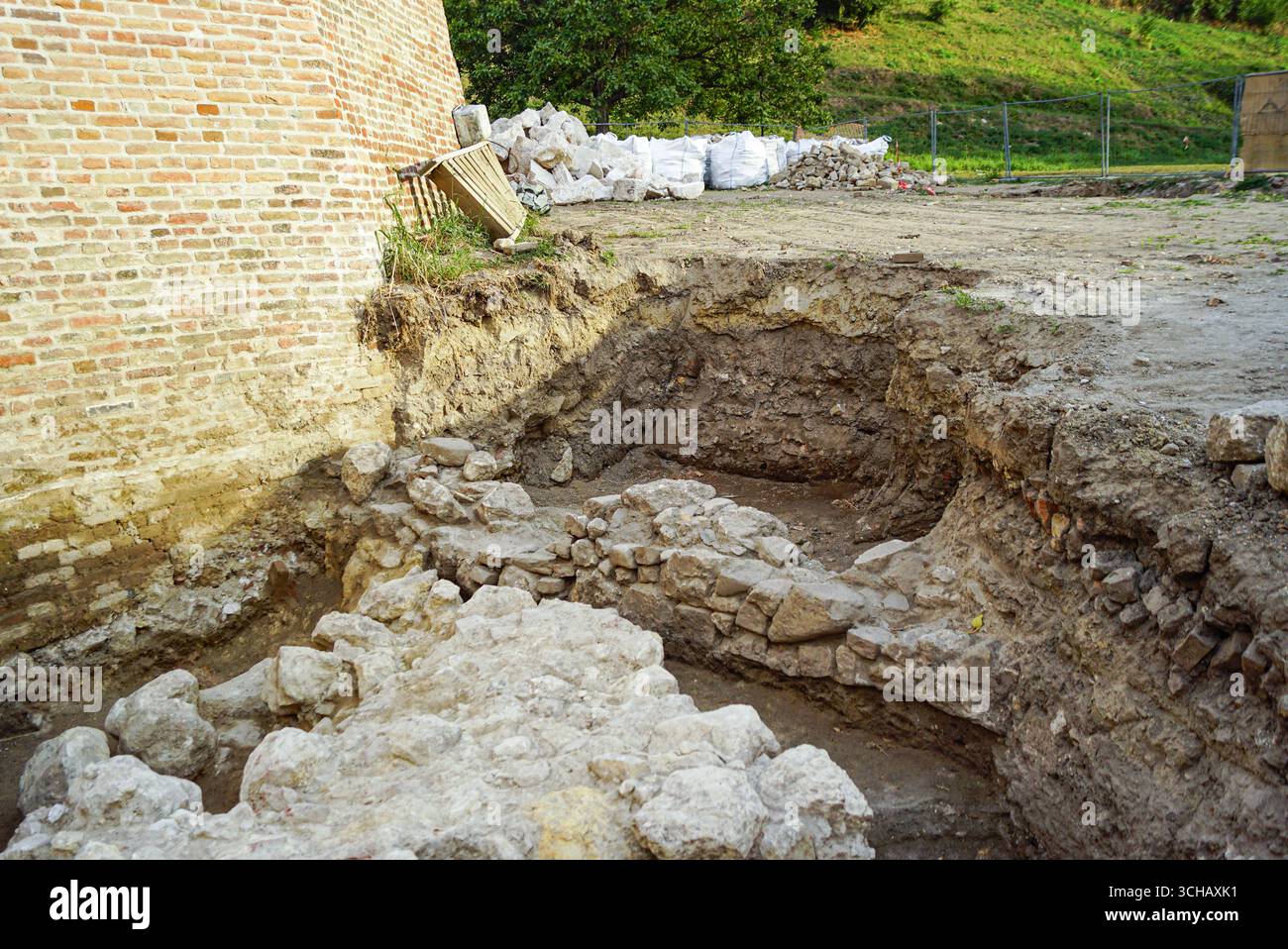 Excavation in an ancient fortress: a brick defensive wall and excavated ...