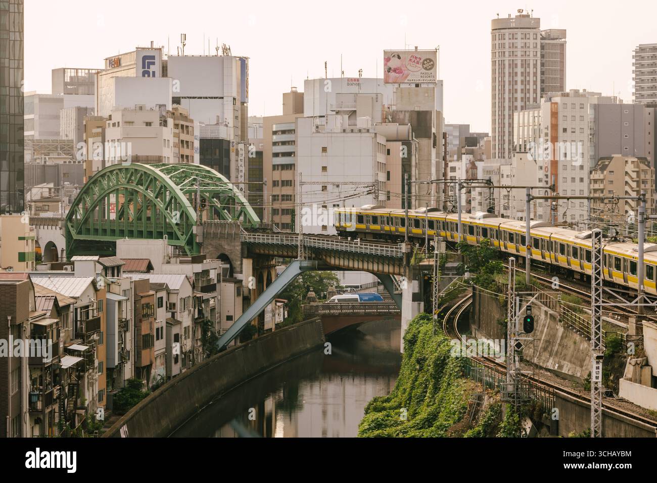Tokyo train crossing Kanda river on a bridge with Akihabara cityscape ...
