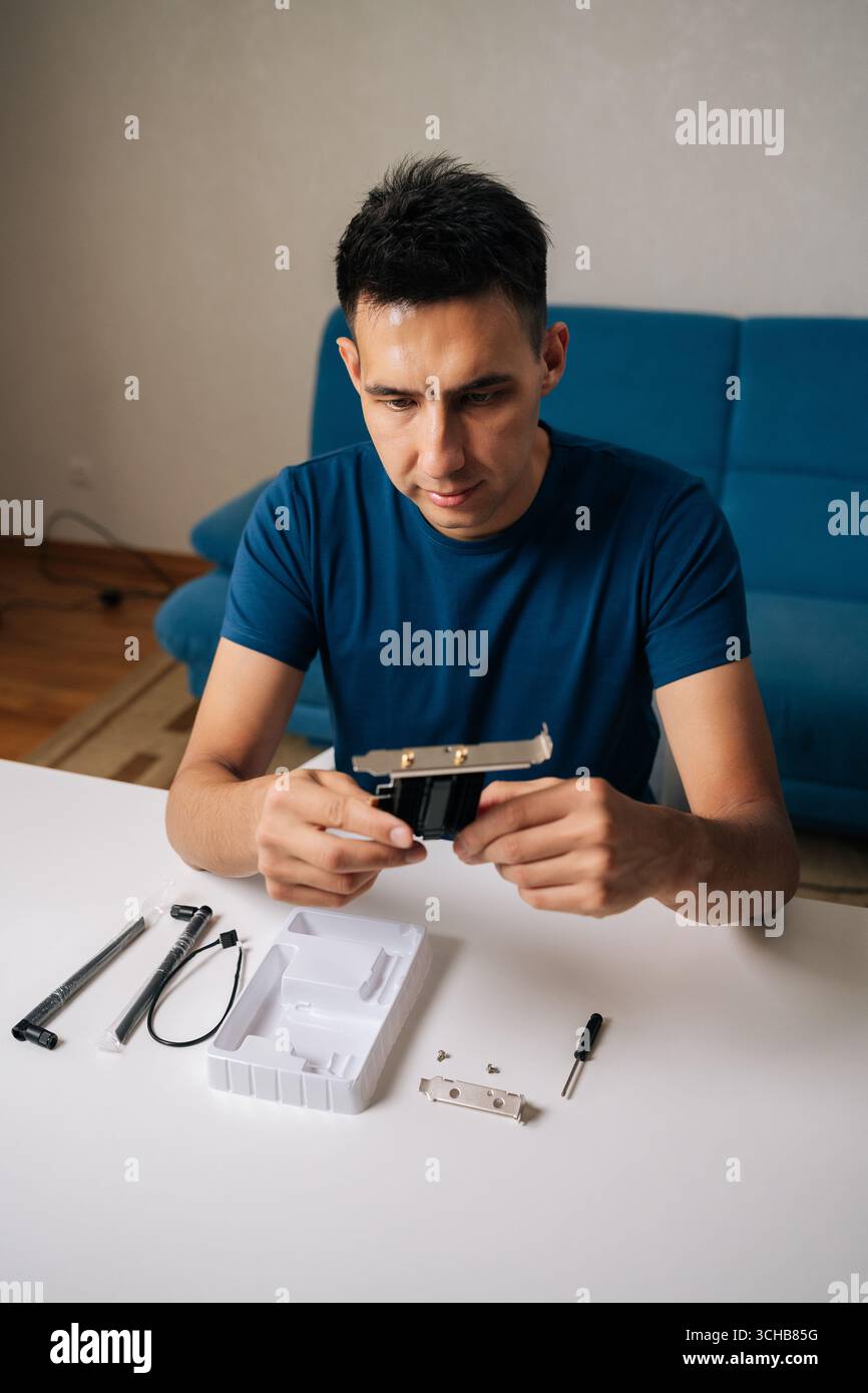 Vertical portrait of skilled technician male assembling wi-fi module ...