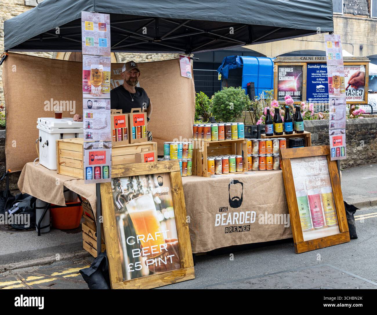 Pop-up stall selling craft beer under a tent with a variety of colorful ...