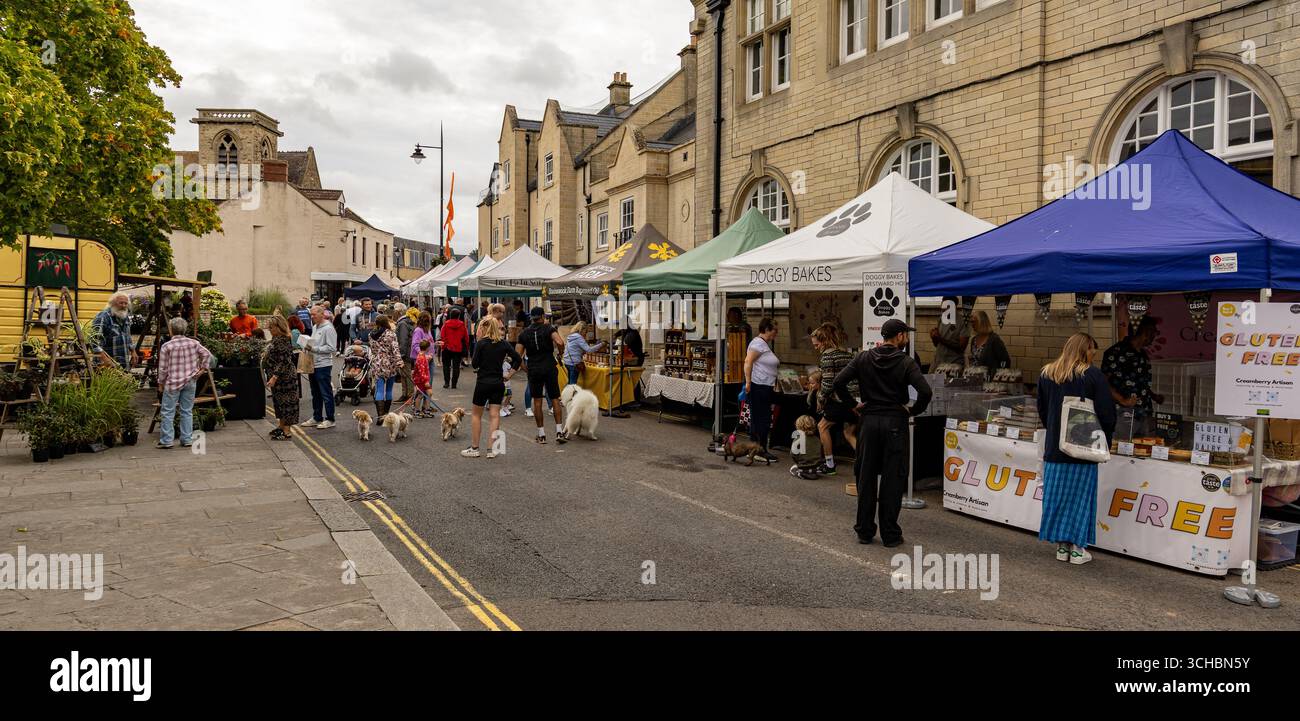A bustling street market with stalls selling various products and ...
