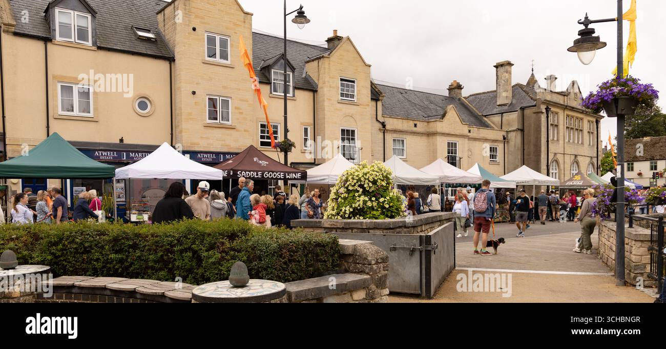 Bustling outdoor market with people exploring diverse stalls amongst ...