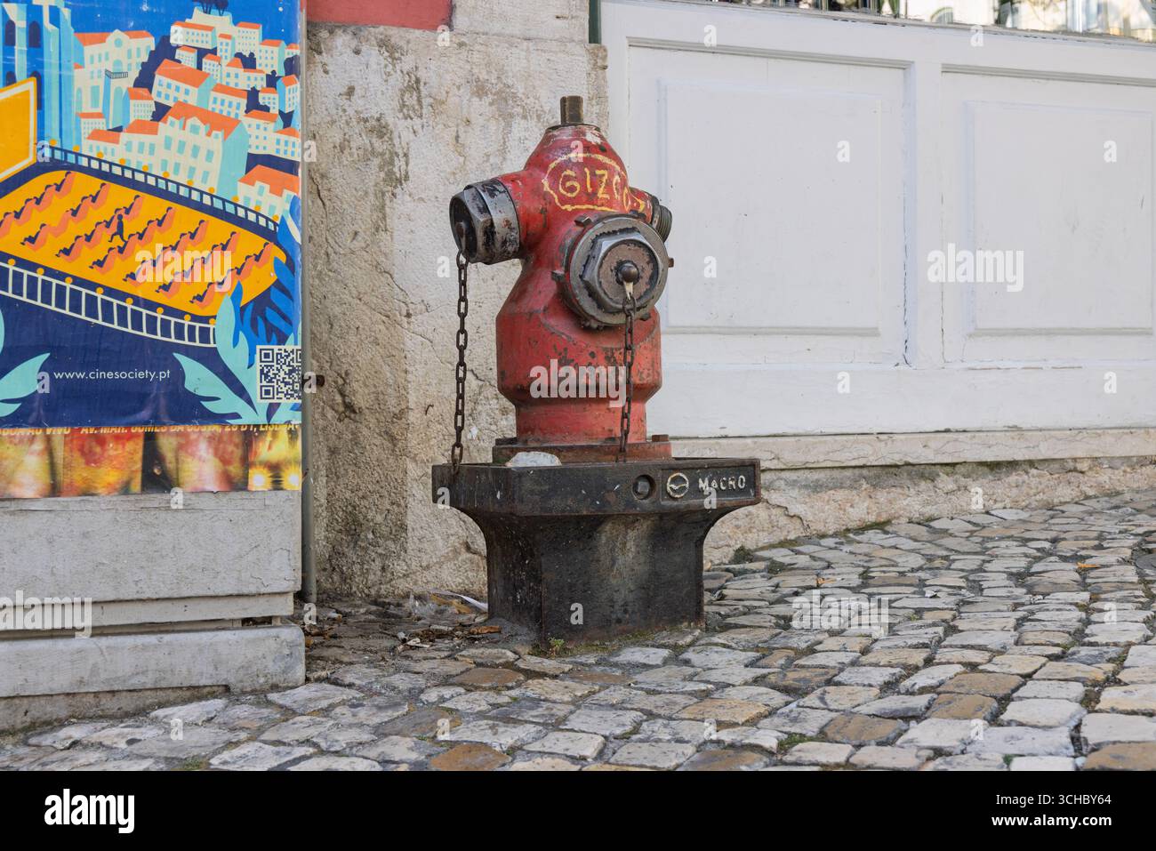 A weathered, bright red fire hydrant sits on a traditional cobblestone ...