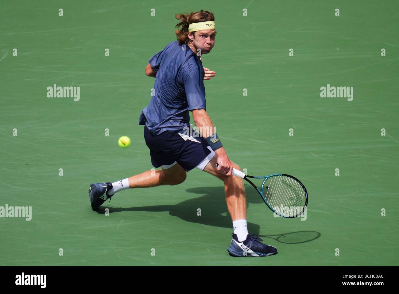 Andrey Rublev, of Russia, returns a shot against Alex de Minaur, of Australia, during the fourth ...