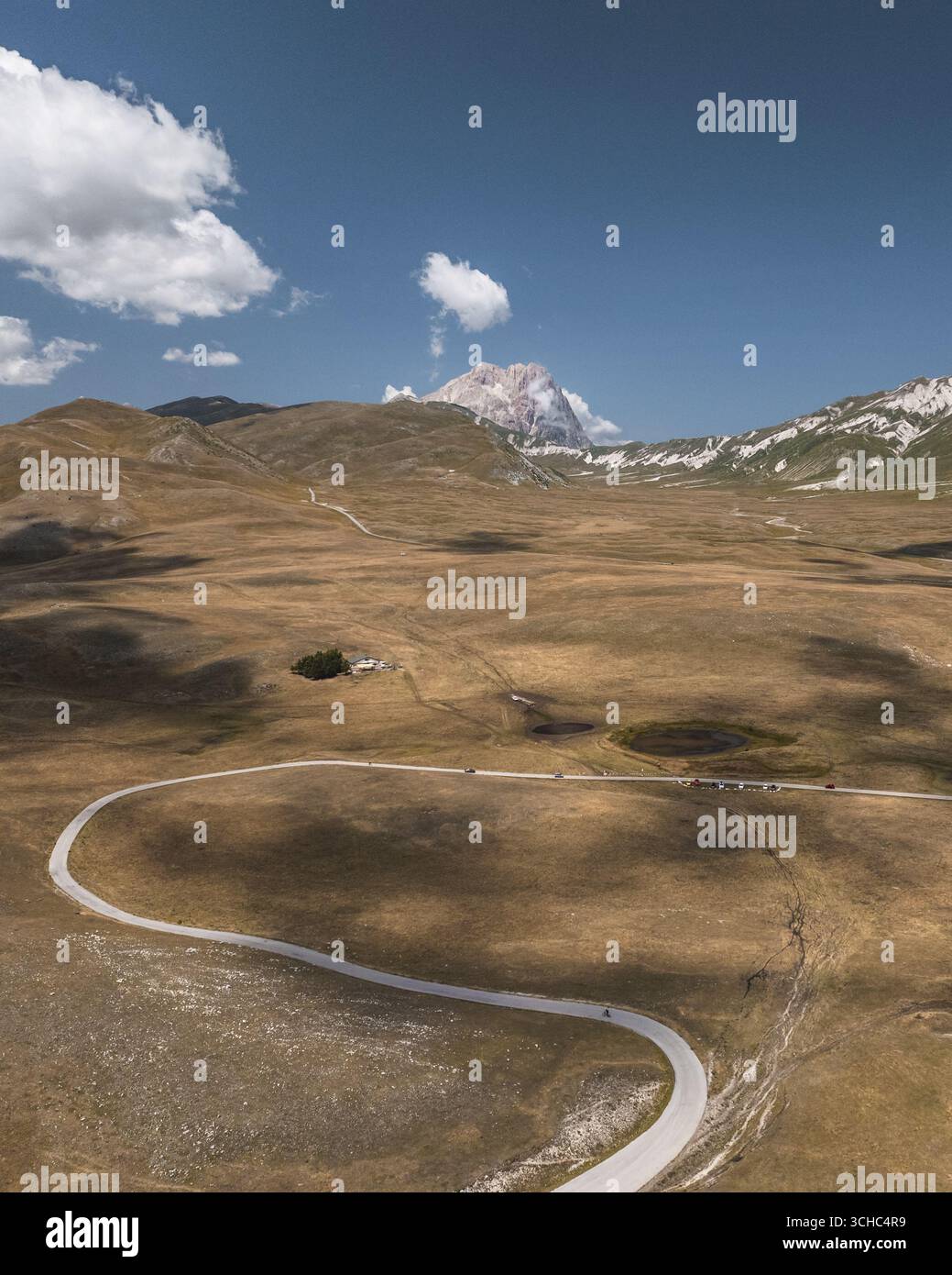 Aerial view of the winding road cuts a pale swathe through the golden ...