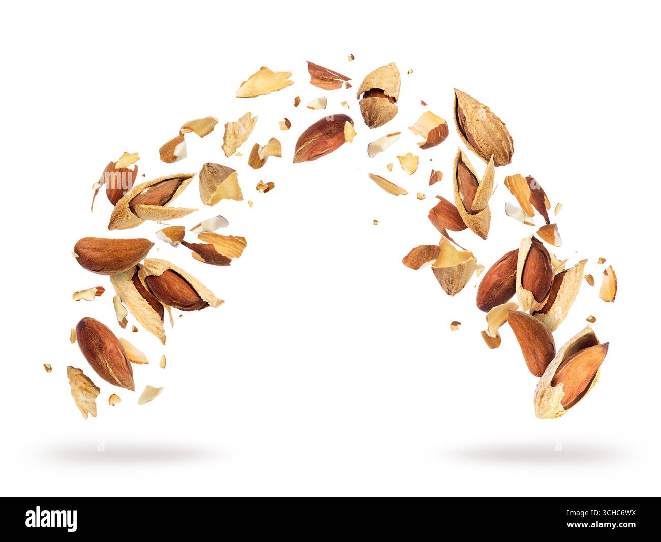 Almonds crushed into pieces, frozen in the air on a white background ...