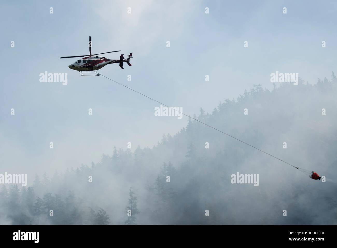 A helicopter drops water on the Dryden Creek Wildfire, just north of ...