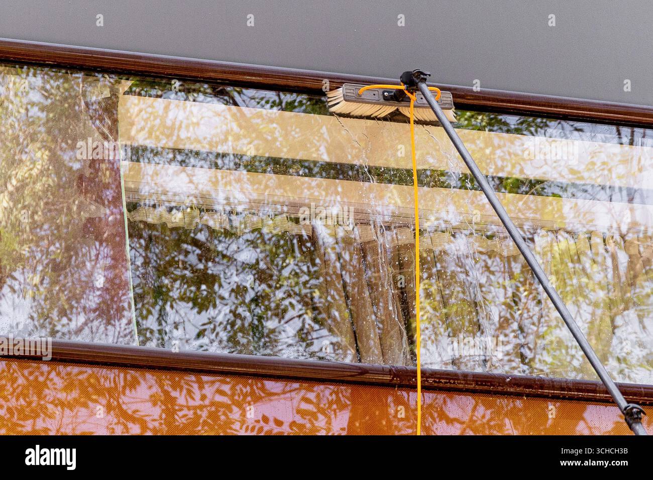 Telescopic water brush cleaning windows on a modern building facade ...