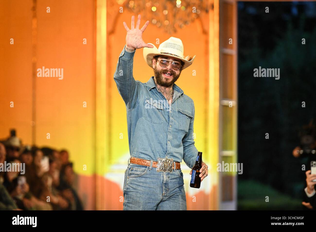 American singer Post Malone cheers attendees at the end of the runway ...