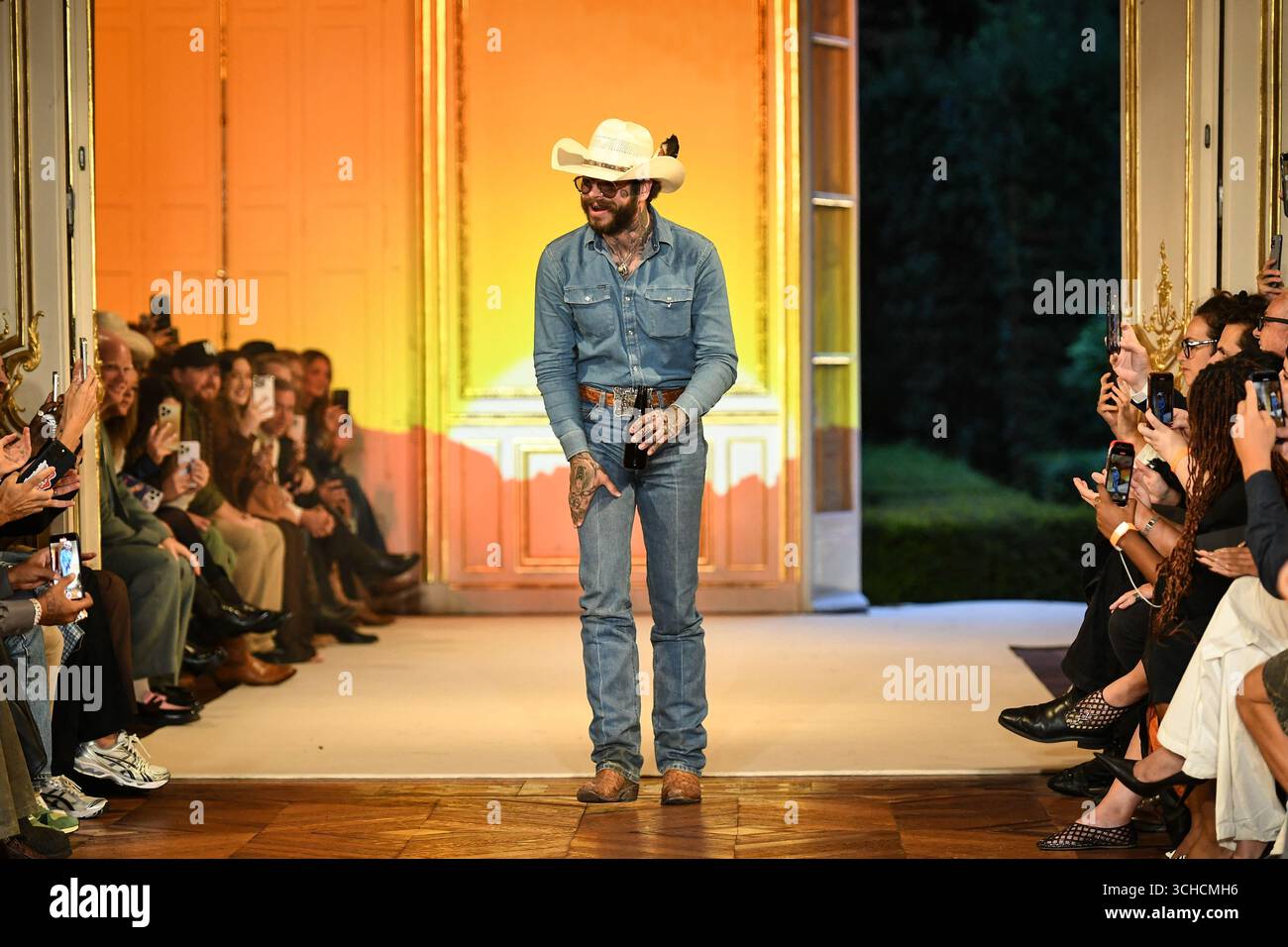 American singer Post Malone cheers attendees at the end of the runway ...