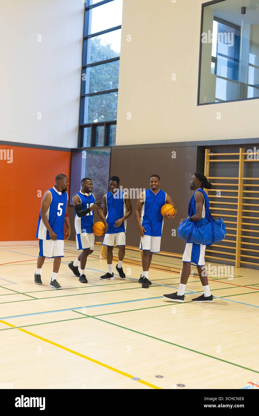 African American male athletes warming up on sports court wearing blue ...
