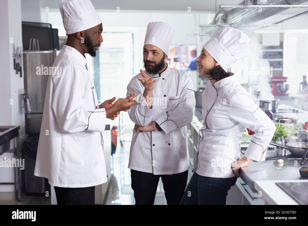 Culinary experts focus on cooking new dishes in a modern kitchen ...