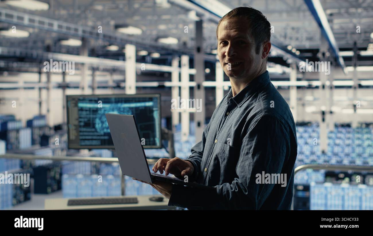 Engineer in data center checks AI dashboard using laptop during routine systems review. IT ...