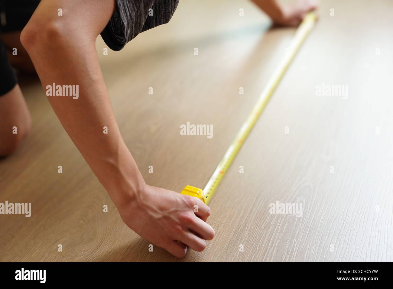 Concept of renovation and moving , A man measuring the floor with a ...