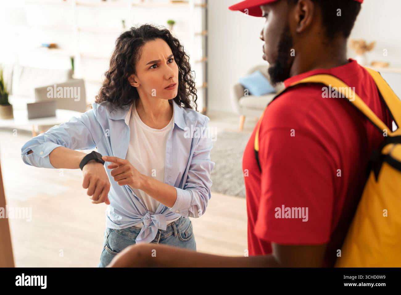 Angry customer pointing at watch, delivery man is late Stock Photo - Alamy