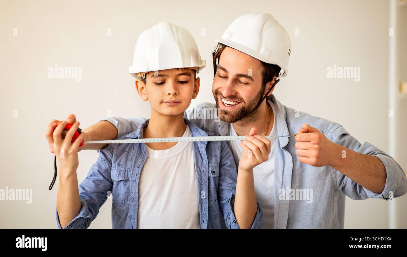 Happy dad and his son making measurements using roulette, dad teaching ...