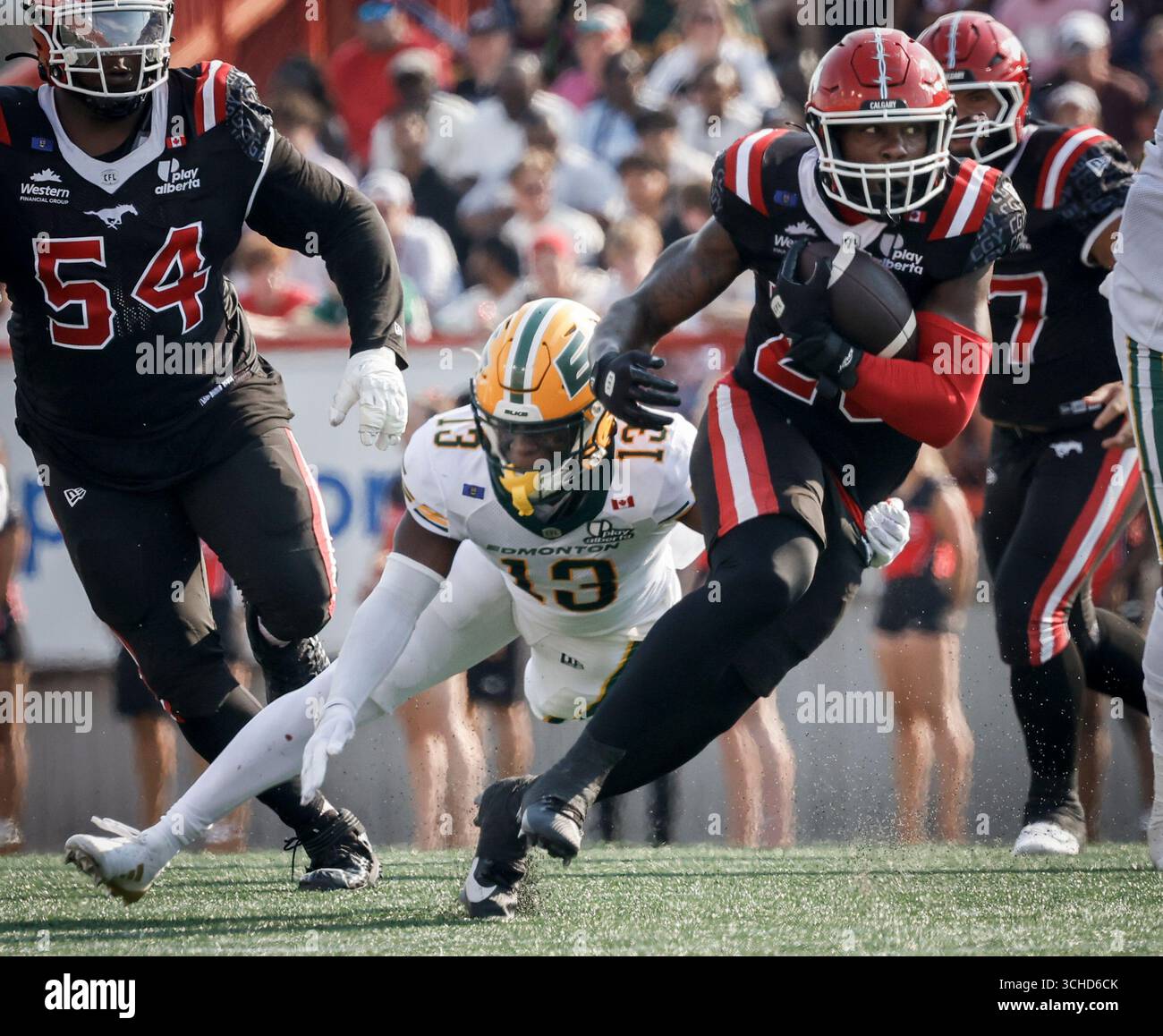 Edmonton Elks' Kordell Jackson (13) grabs for Calgary Stampeders ...
