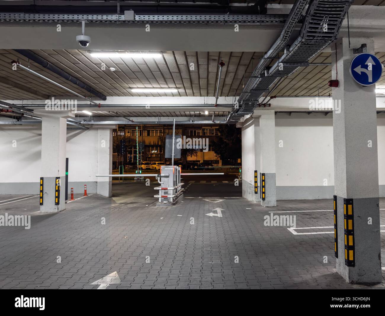 Night view inside an underground parking garage with barrier, ticket ...