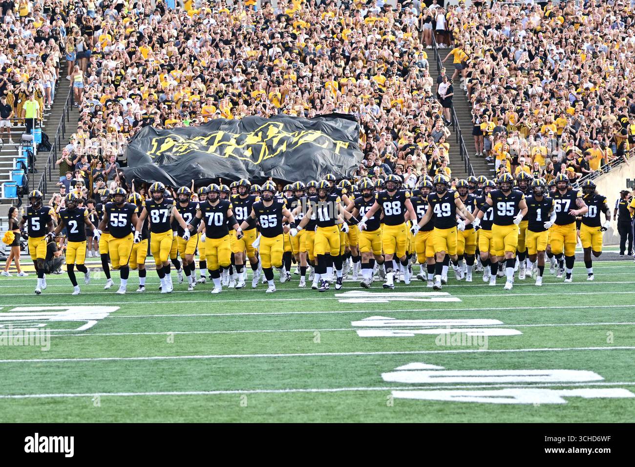 IOWA CITY, IA - AUGUST 30: The Iowa Hawkeyes surge onto the field ...