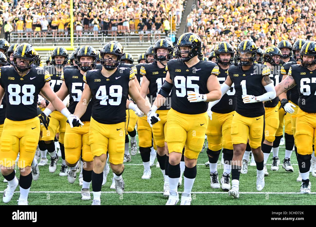 IOWA CITY, IA - AUGUST 30: The Iowa Hawkeyes surge onto th field before ...