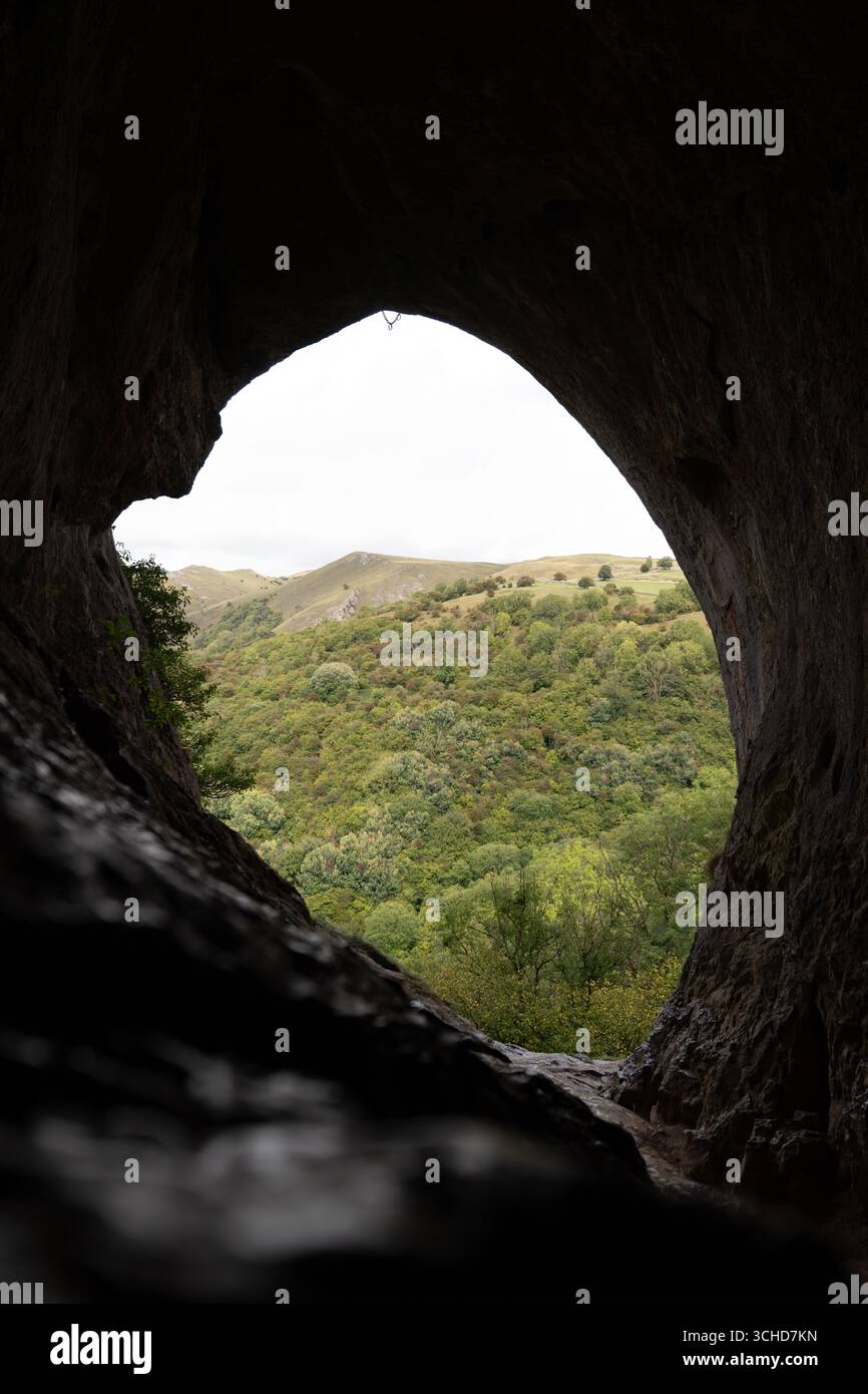 View from inside Thor's Cave framing a green valley in Peak District ...