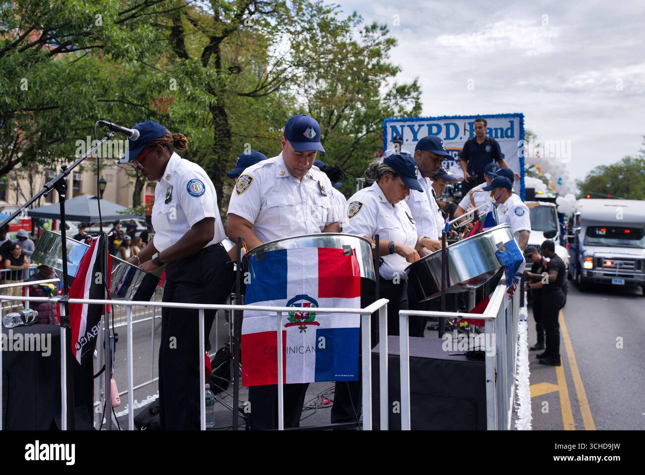 NYPD band members in uniform play steel drums on a parade float, with ...