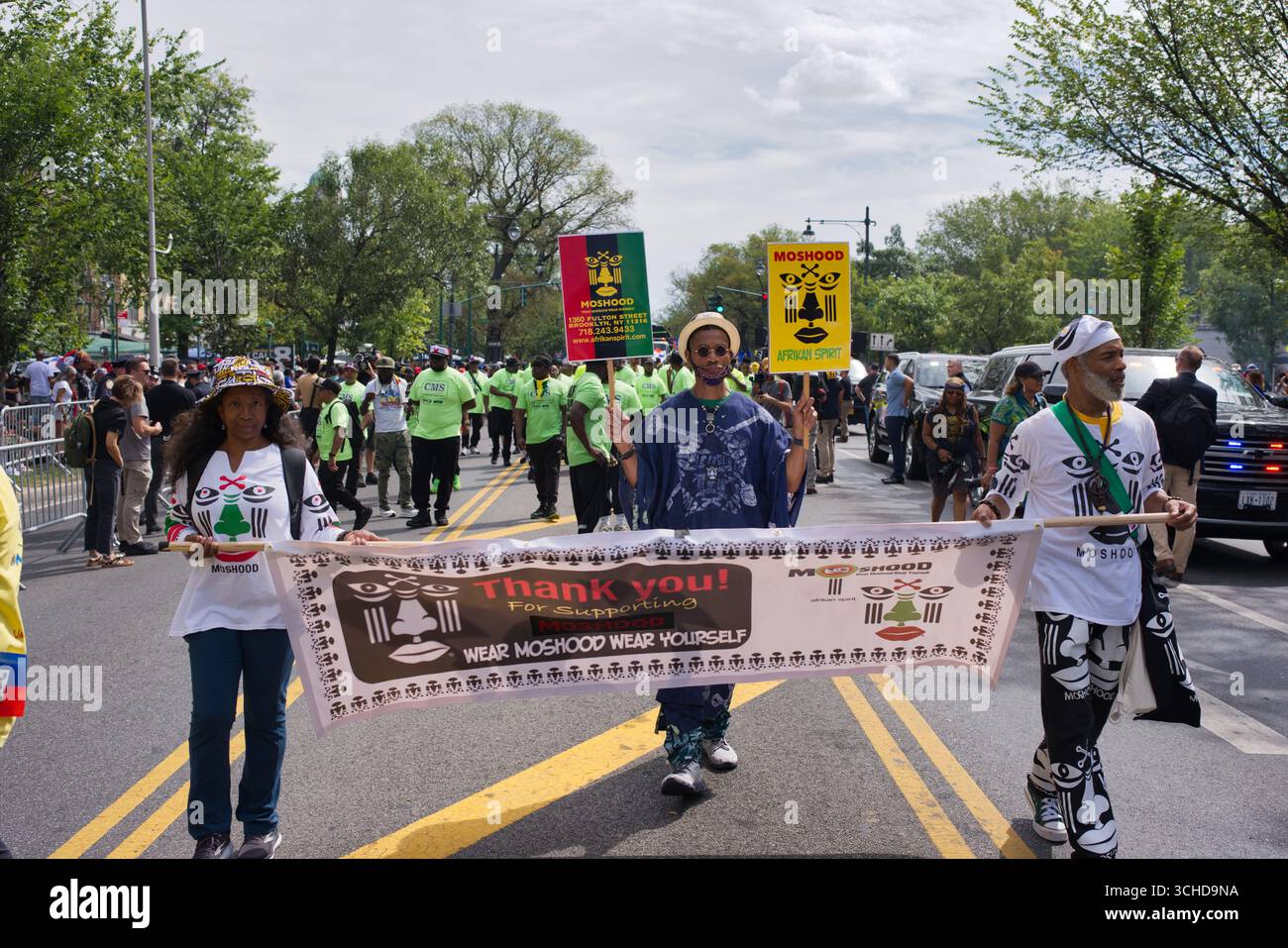 People in a parade are holding a banner and signs. The main people in ...