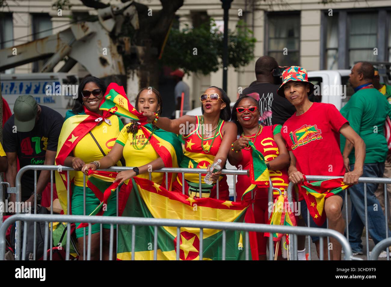 A group of people in the foreground are wearing yellow and red shirts and wearing flags of ...