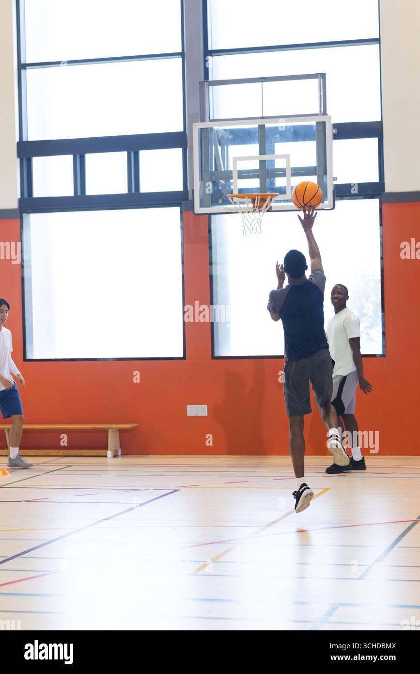 Adult african american male in black gear jumping toward hoop, shooting ...