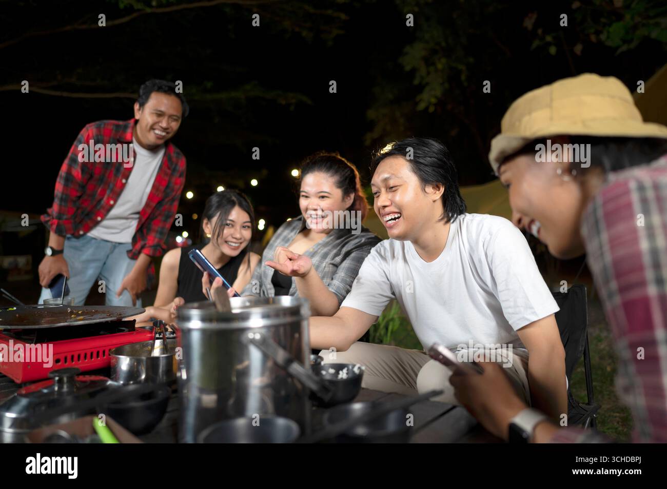 Indonesian southeast asian people enjoying a camping at night, using ...