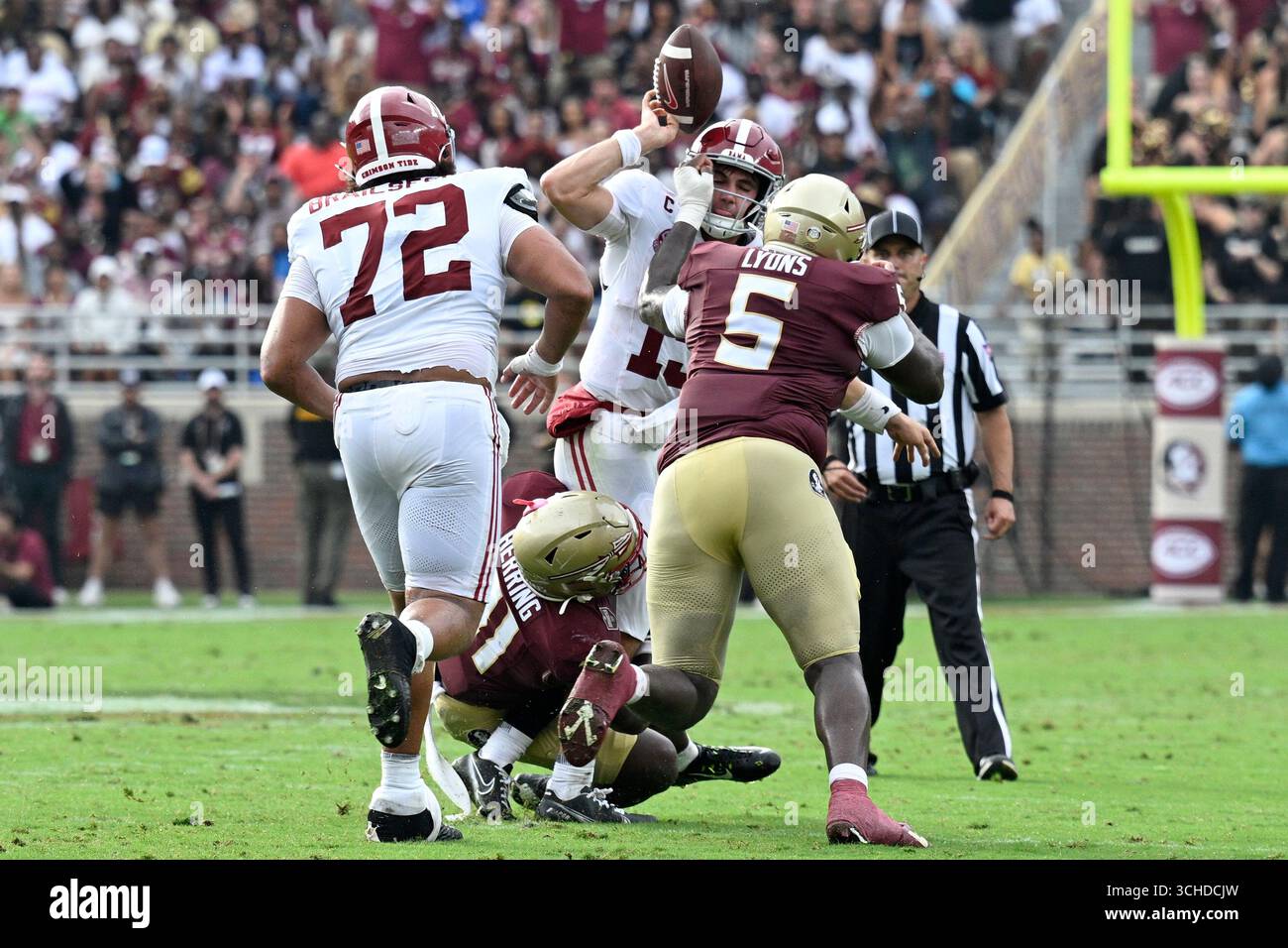 Alabama quarterback Ty Simpson, second from right, fumbles after being ...