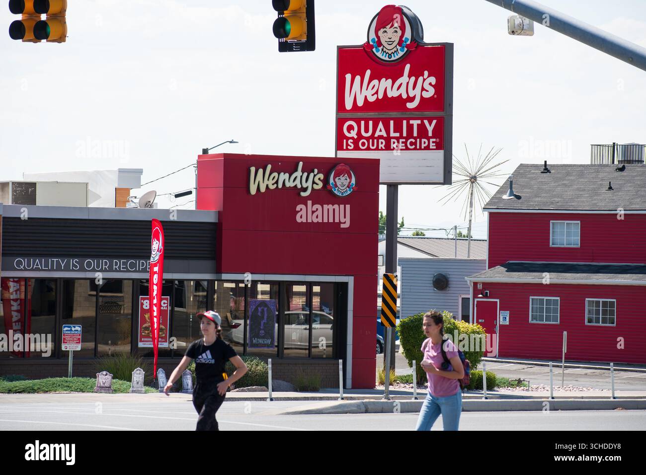Provo, Utah — September 1, 2025: Two pedestrians cross in front of a ...