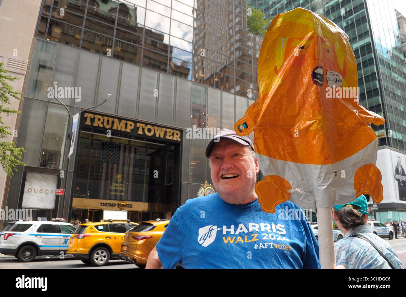 An anti-Trump demonstrator holds a placard of a drawing of Donald Trump ...
