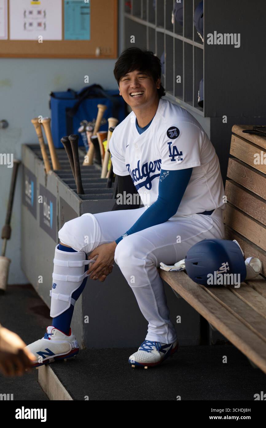 Los Angeles Dodgers' Shohei Ohtani smiles in the dugout before a ...