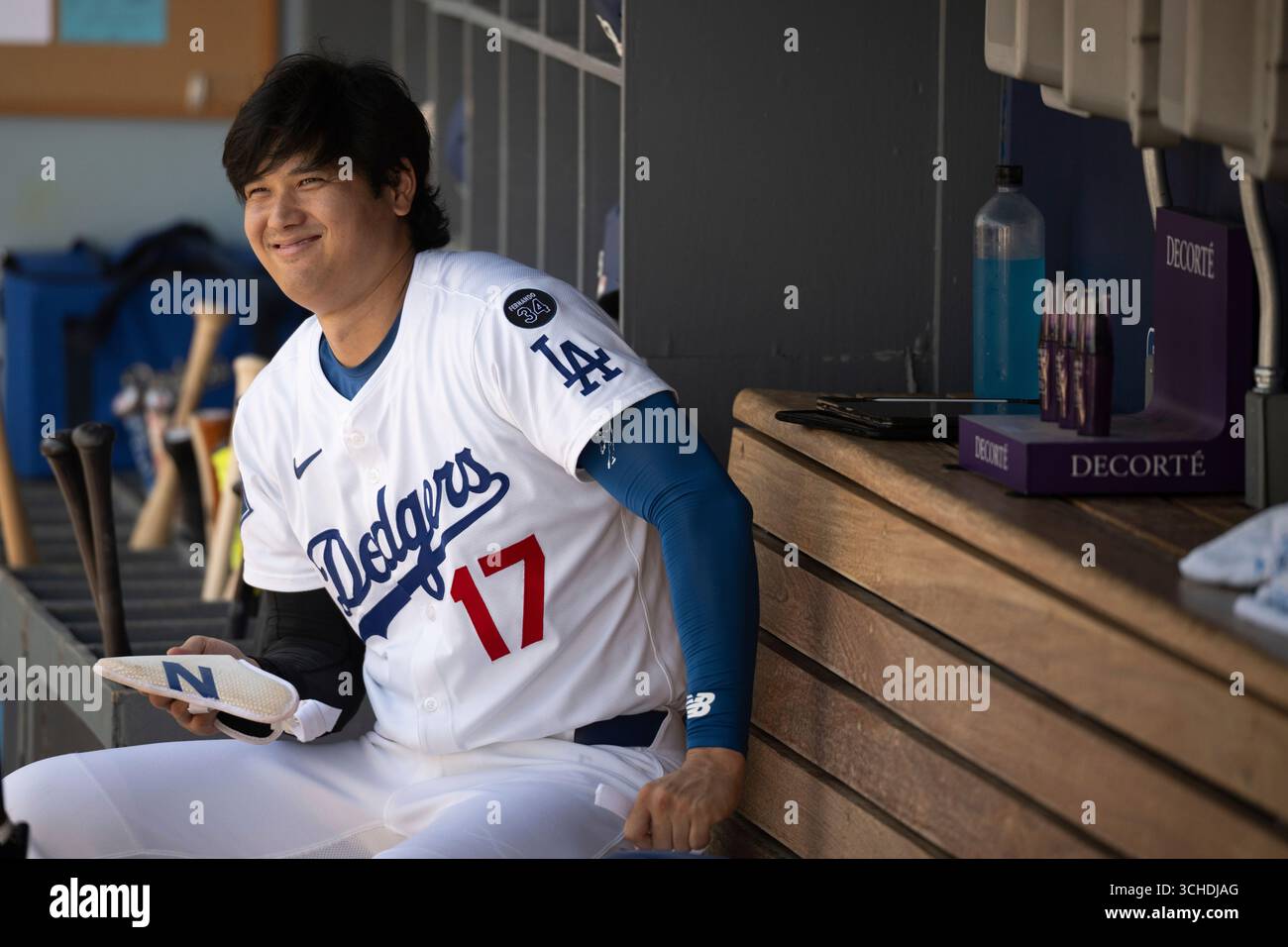 Los Angeles Dodgers' Shohei Ohtani smiles in the dugout before a ...
