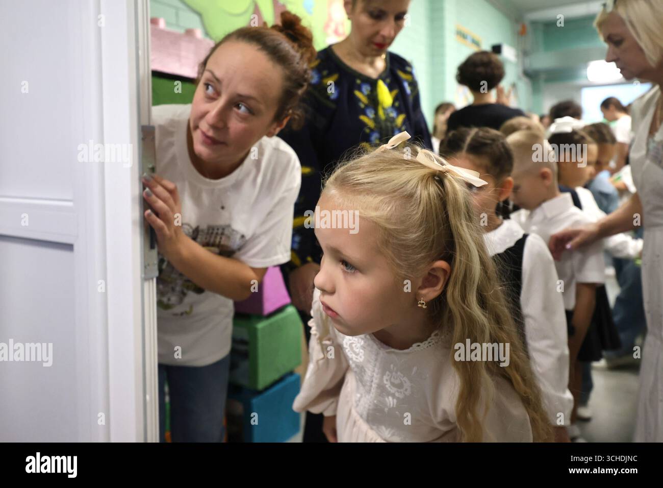 Non Exclusive: A woman and a first-grade girl peek into a classroom of ...