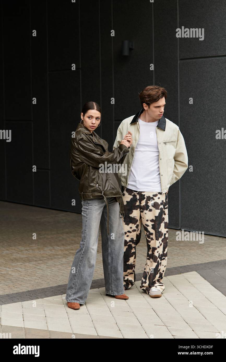 In a trendy urban location, a young couple shares a lighthearted moment ...