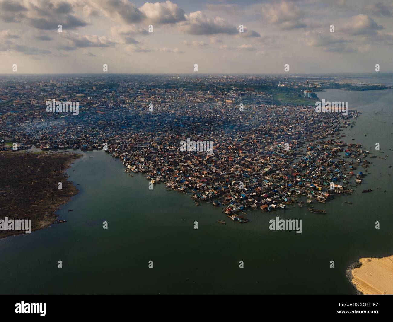 Aerial view of a dense settlement of houses on stilts over water ...