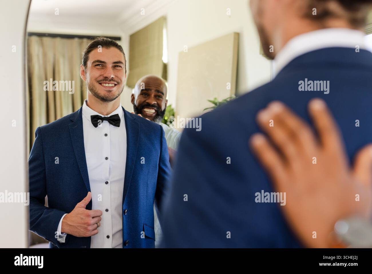 Wedding suits, two men standing in dressing room, with tuxedo jacket ...