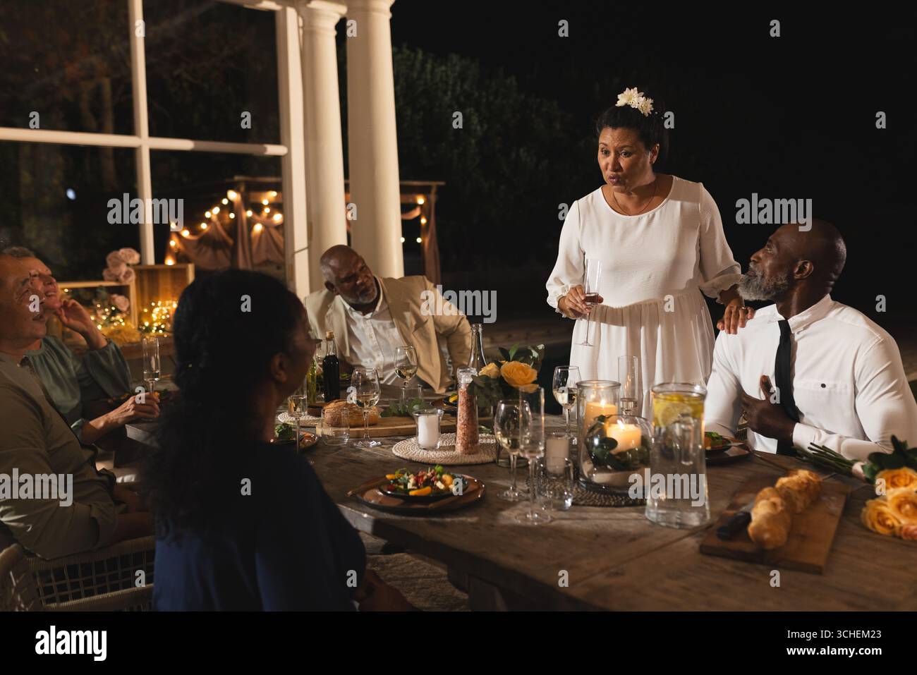 Giving speech at outdoor dinner party, African American woman engaging ...