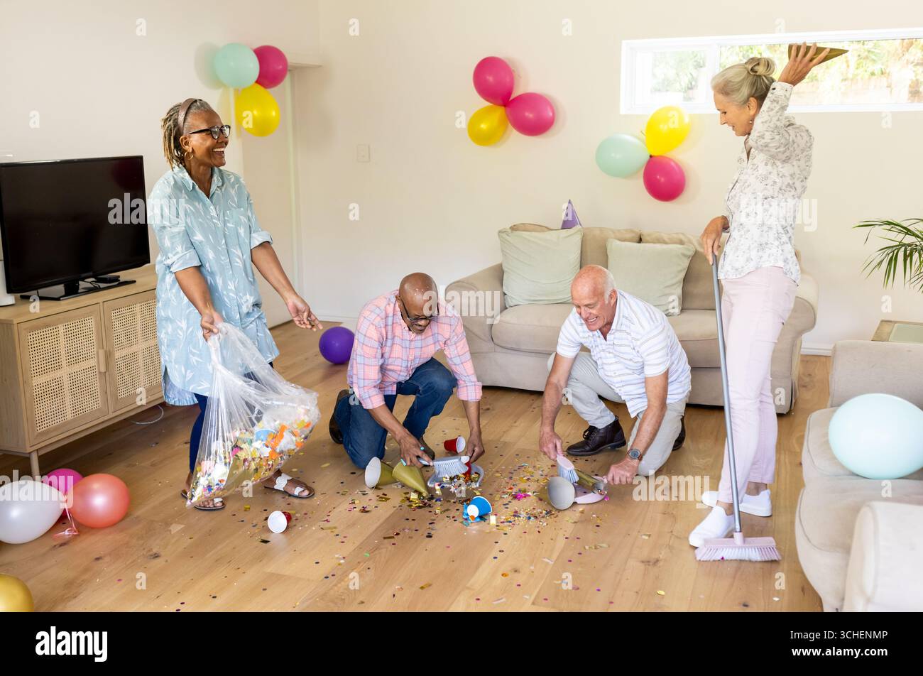 Senior diverse friends cleaning up after party, picking up confetti and ...