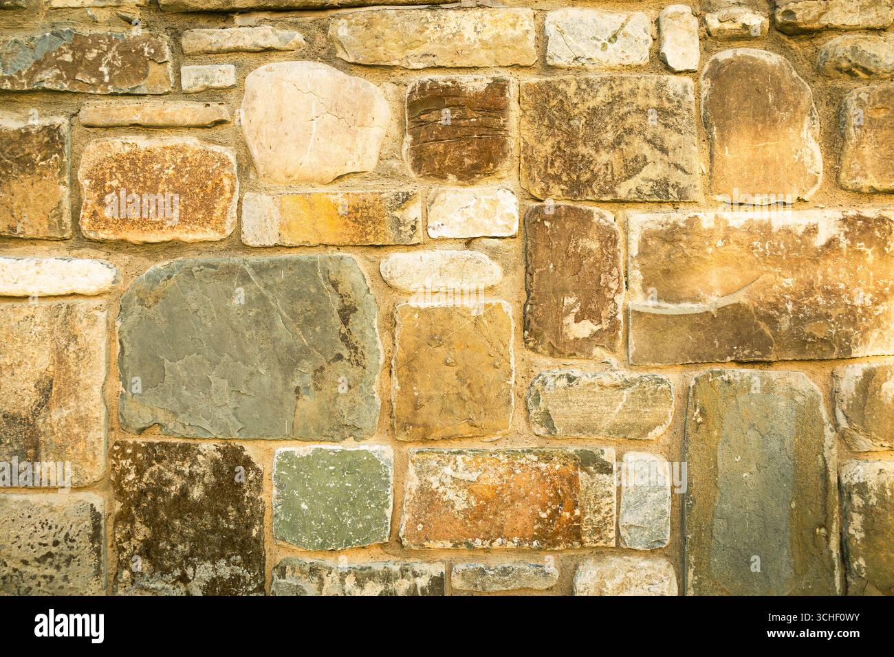 Colorful textured stone wall made of various types of masonry blocks in ...