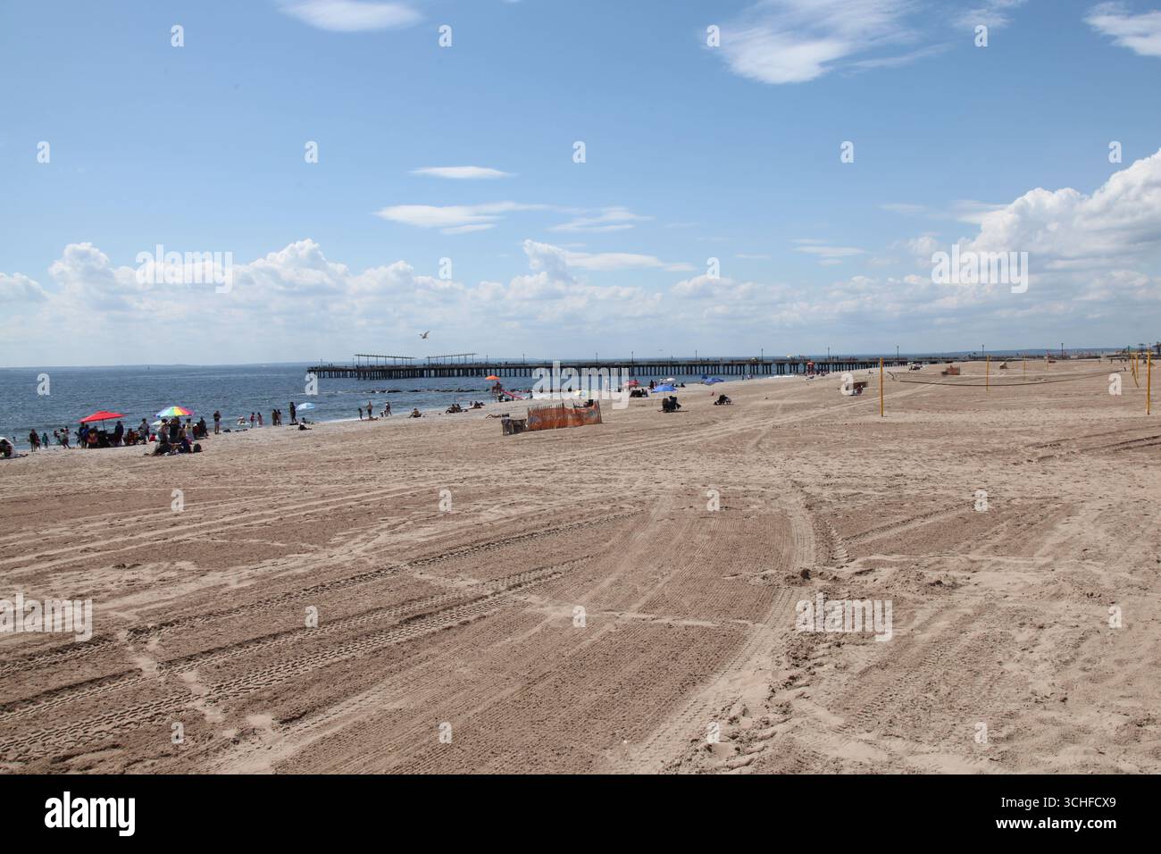 Coney Island beach, a sandy shoreline, a pier extending into the ocean ...