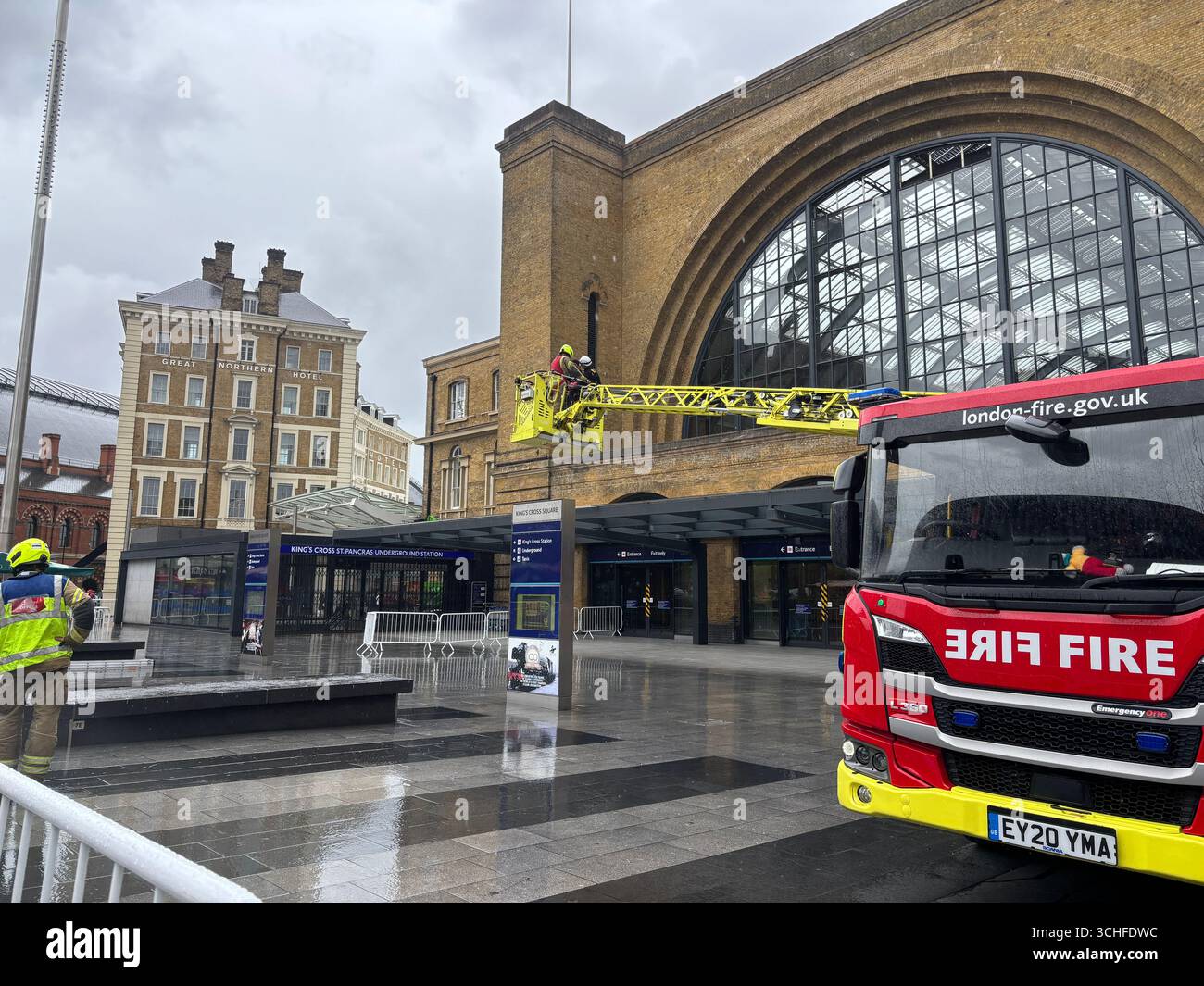 A London Fire Brigade cherry picker lowers a protester to the ground ...