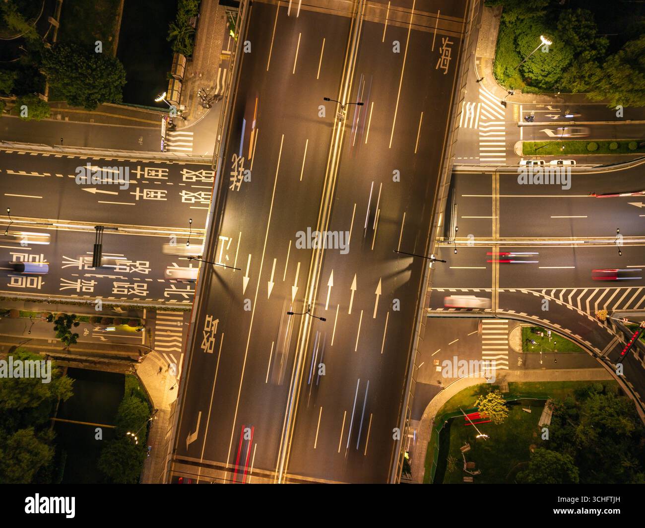 Aerial view of cars move along a brightly illuminated highway ...