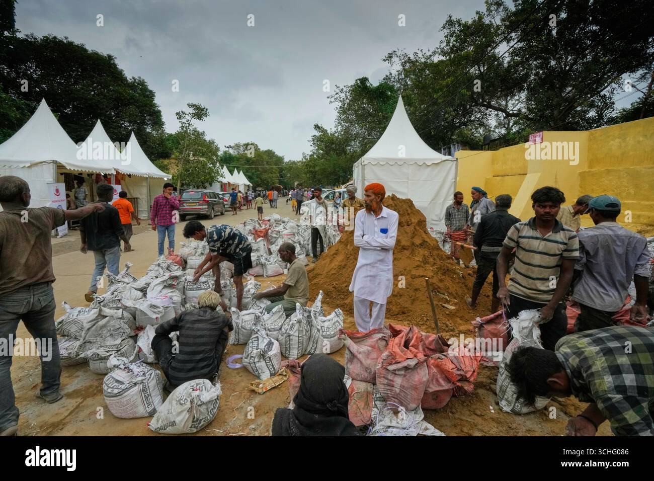 Workers prepare sand bags to stop floodwater after the river Yamuna ...