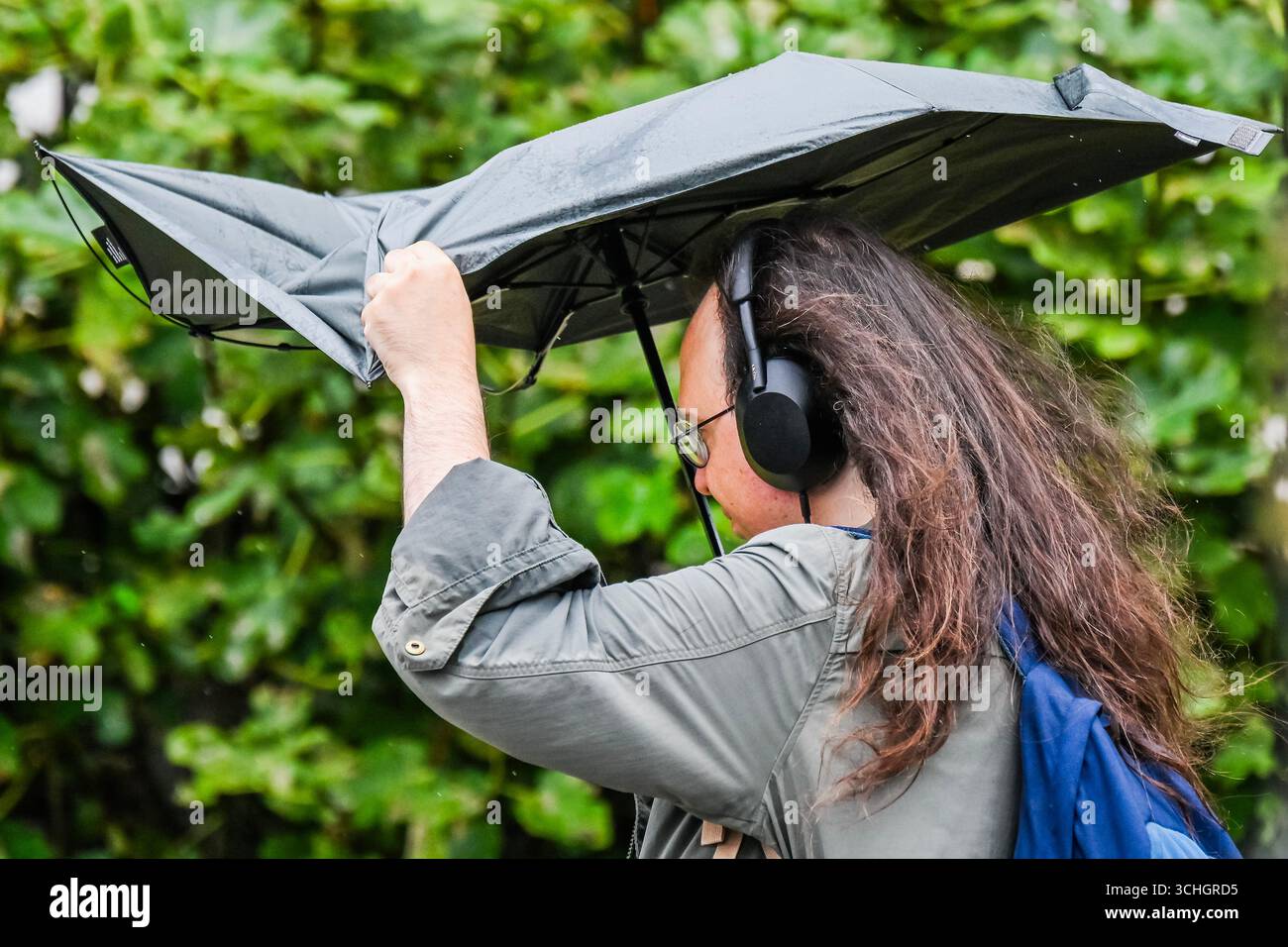 London, UK. 2 Sep 2025. Keeping control of umbrellas in teh gusty wind ...