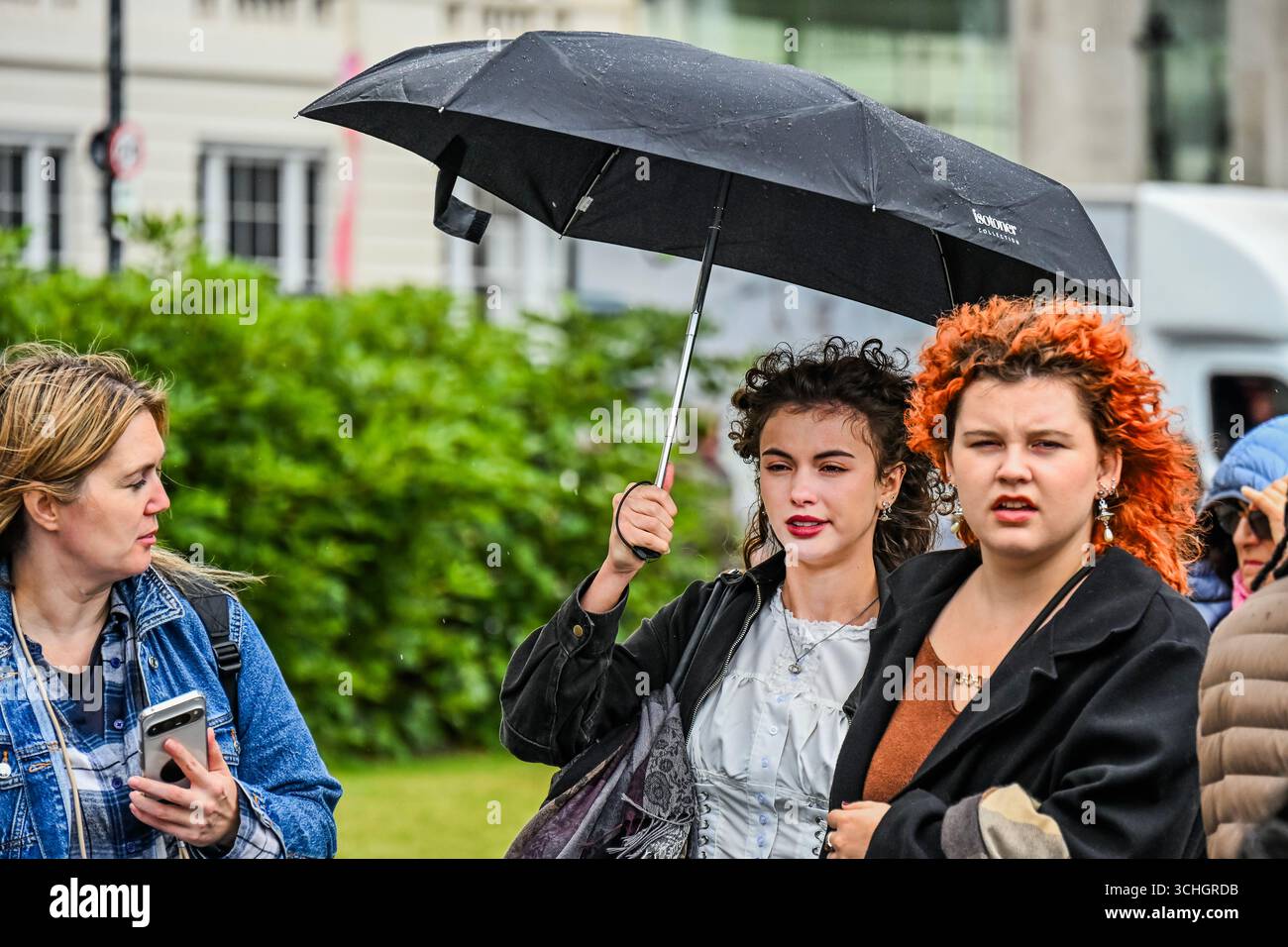London, UK. 2 Sep 2025. Keeping control of umbrellas in teh gusty wind is not always successful ...