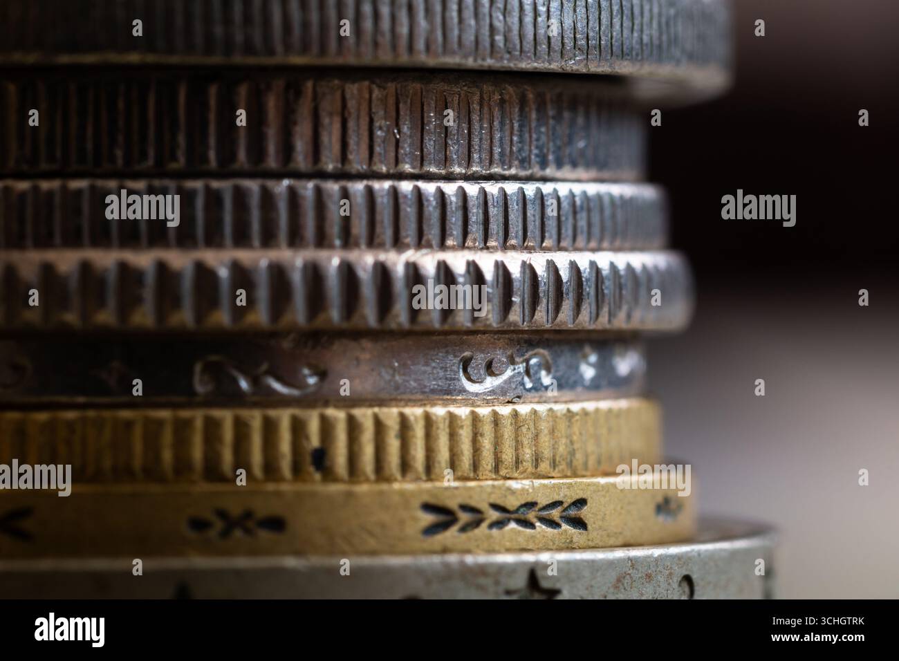 Edges of various coins stacked in pile close up, reeded and decorated ...
